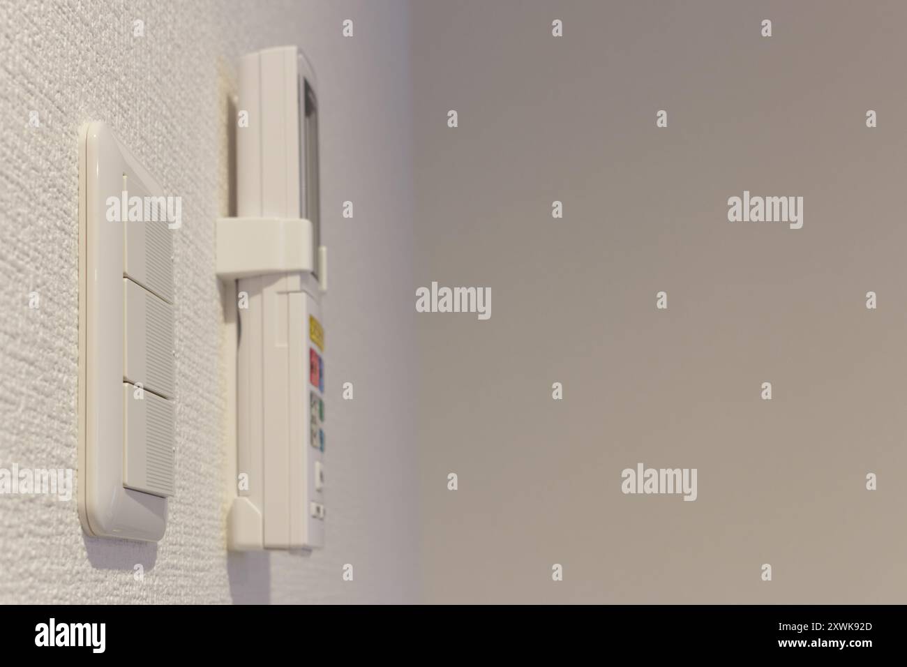 Air conditioner remote control on white interior house wall Stock Photo ...
