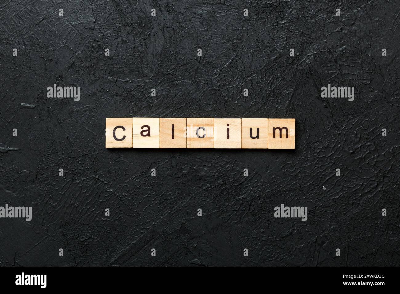 CALCIUM word written on wood block. CALCIUM text on cement table for ...