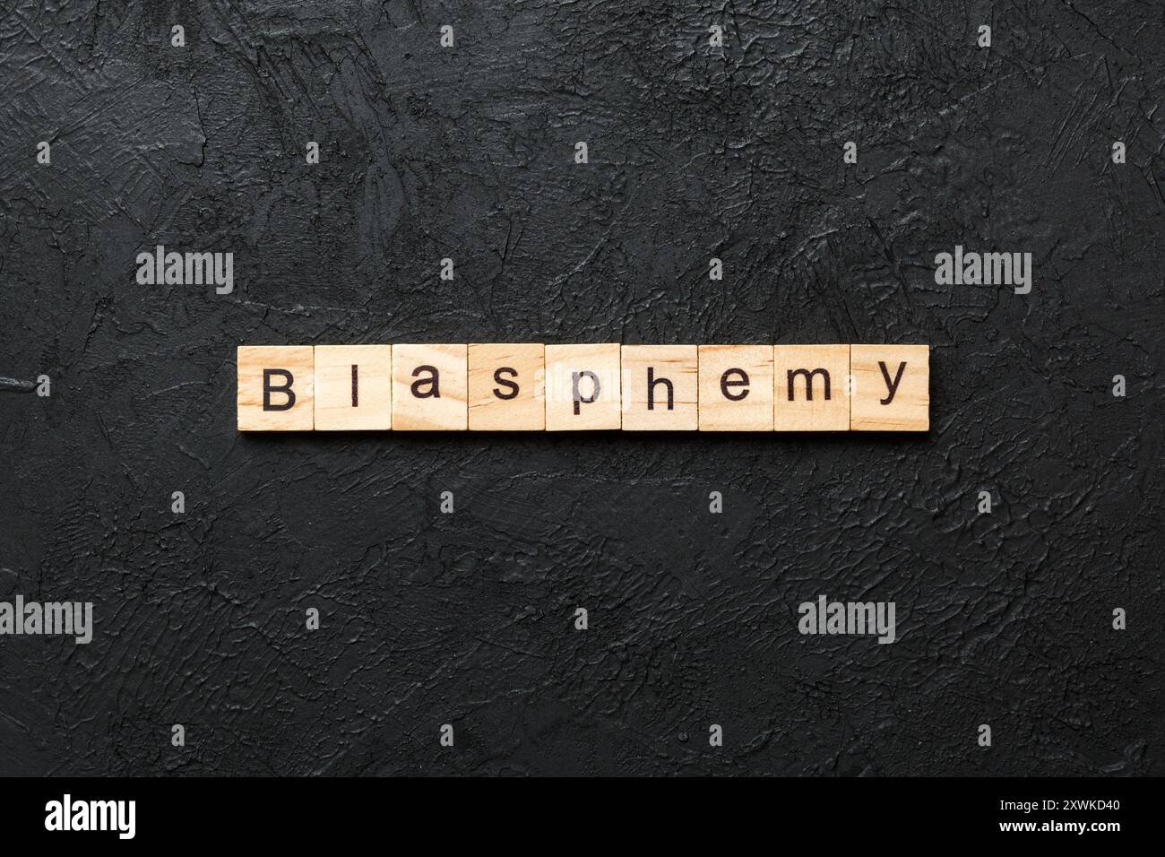 BLASPHEMY word written on wood block. BLASPHEMY text on cement table ...