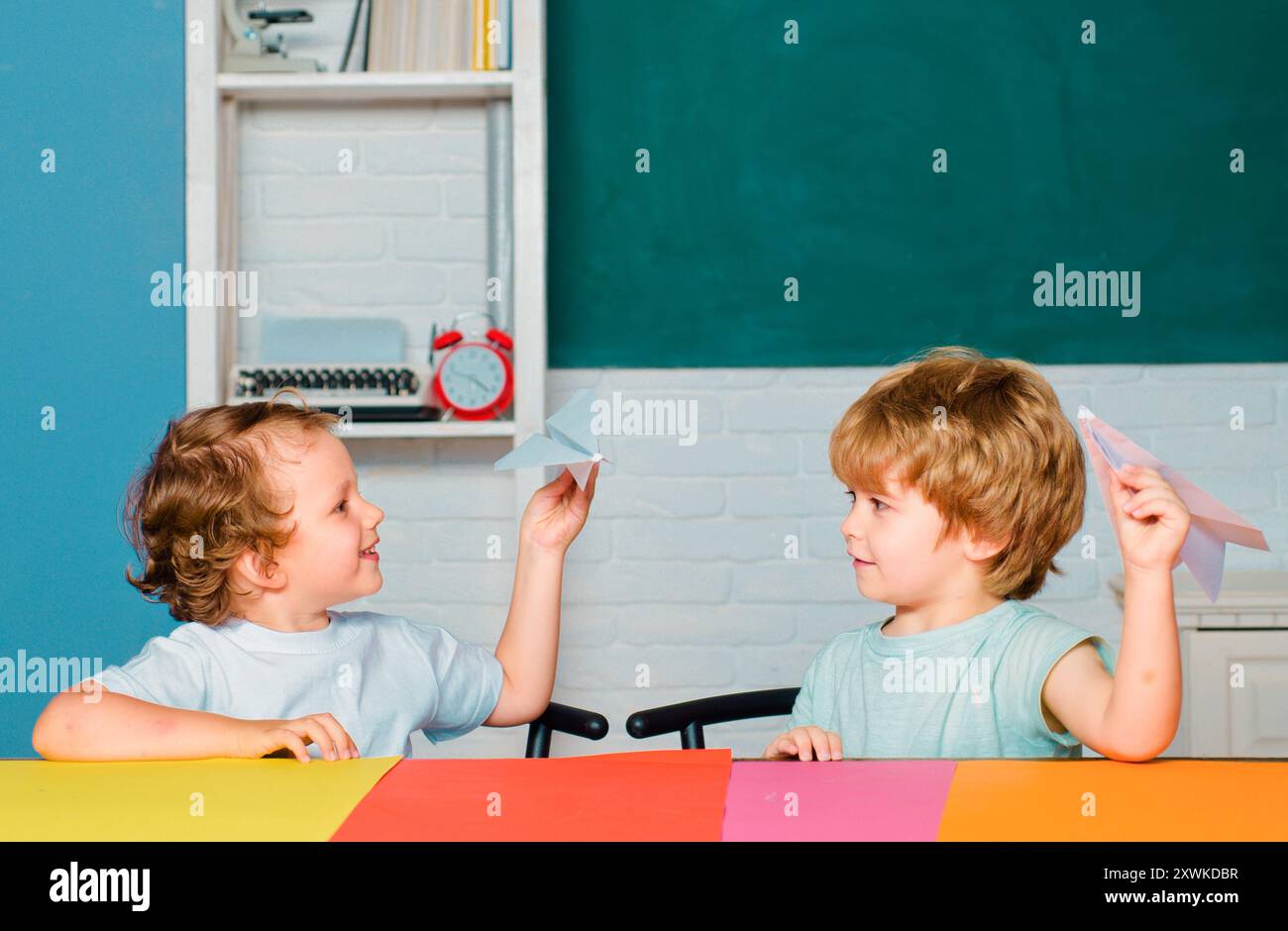 Funny toddlers from elementary school hold paper plane laughing and ...