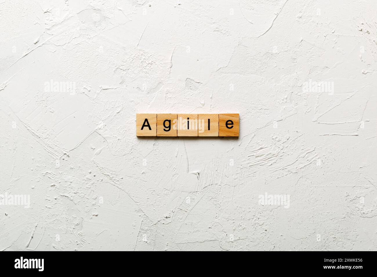 Agile word written on wood block. Agile text on cement table for your ...