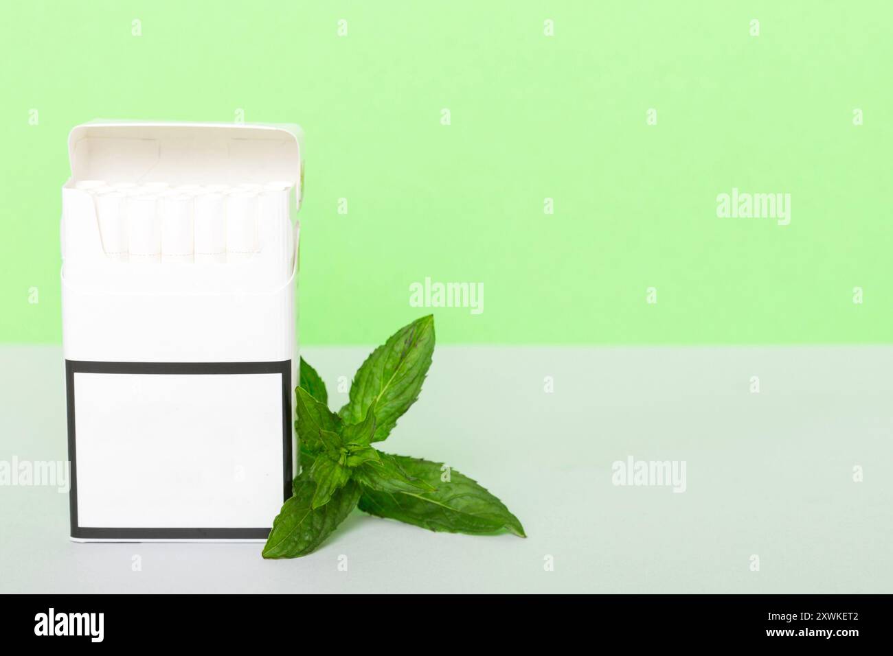Pack of menthol cigarettes and fresh mint on colored table, Menthol ...