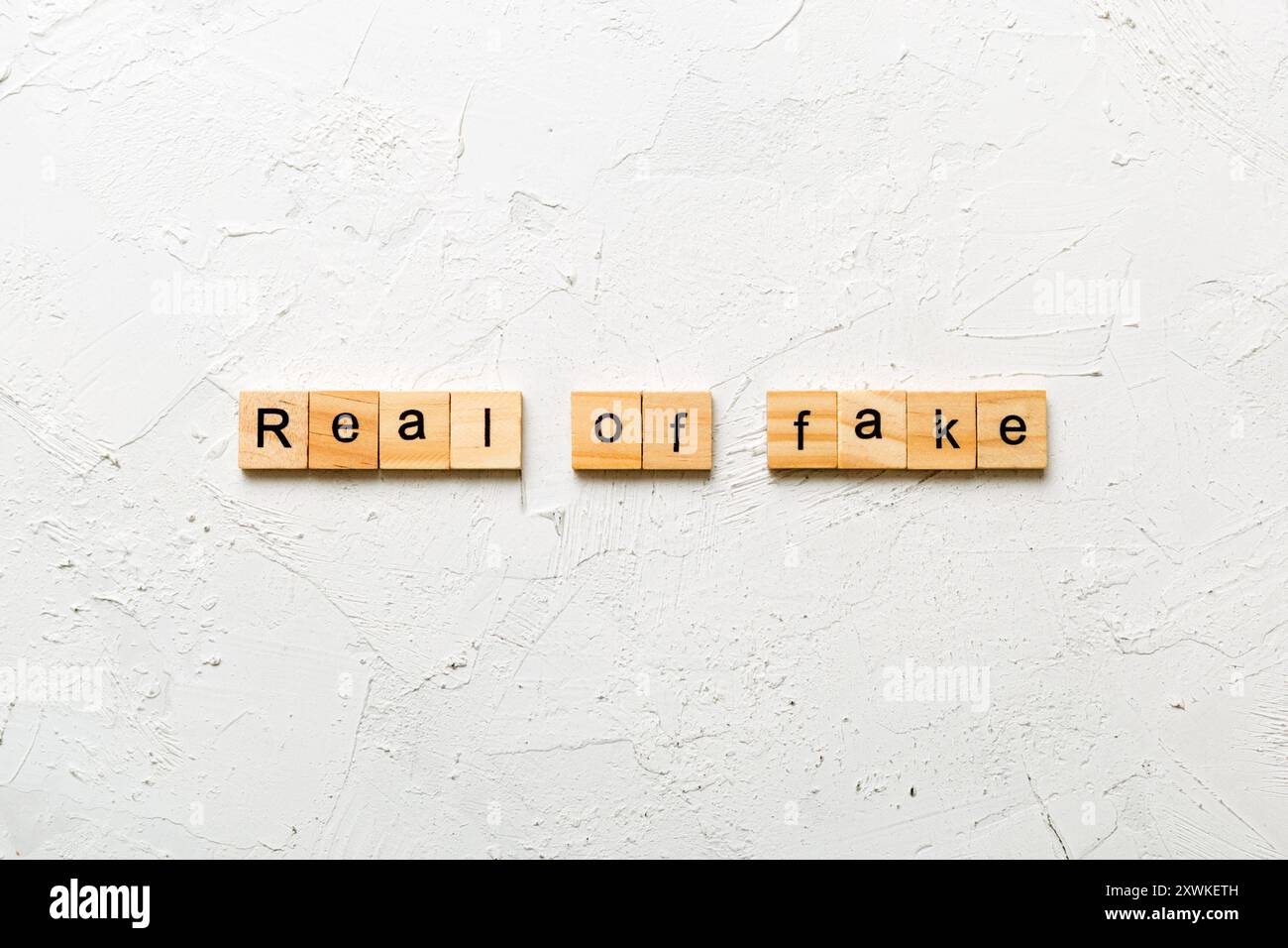 Real or fake word written on wood block. Real or fake text on cement ...