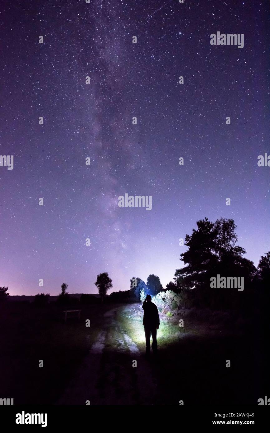 a person walking in the countryside at night with a head torch under ...