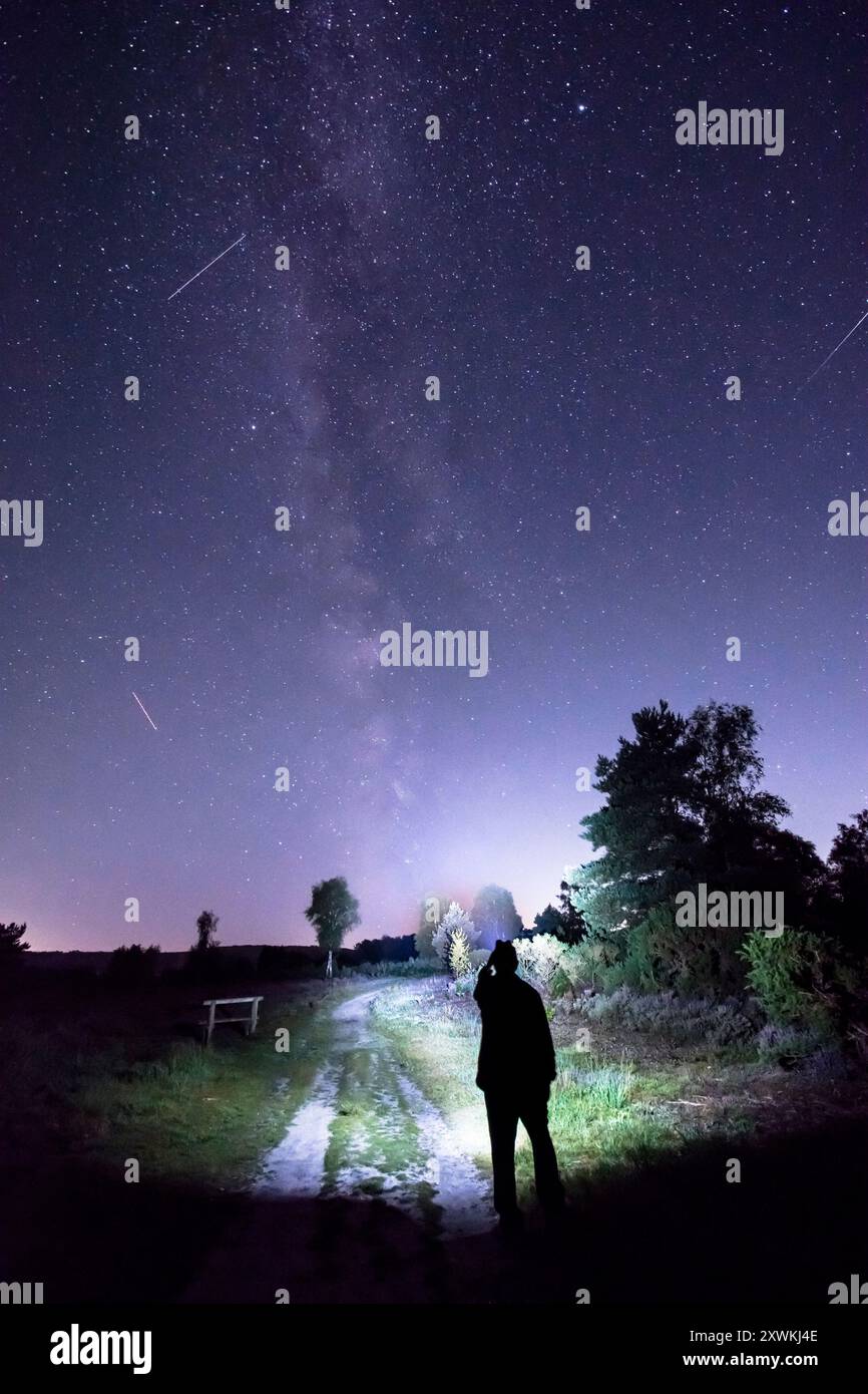 a person walking in the countryside at night with a head torch under ...