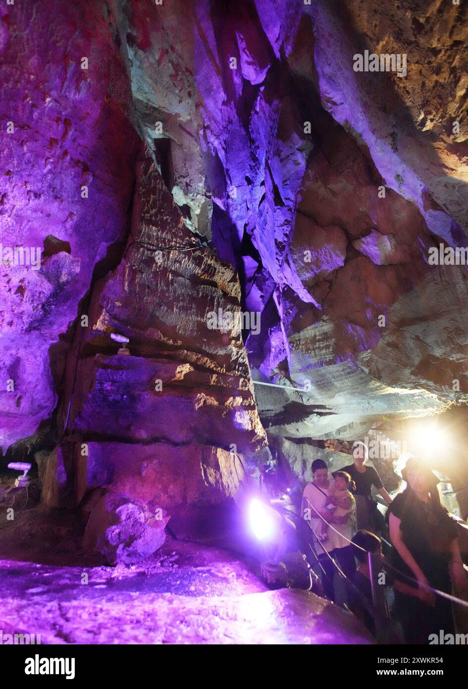 People visit an illuminated limestone cave to cool off in the lingering ...