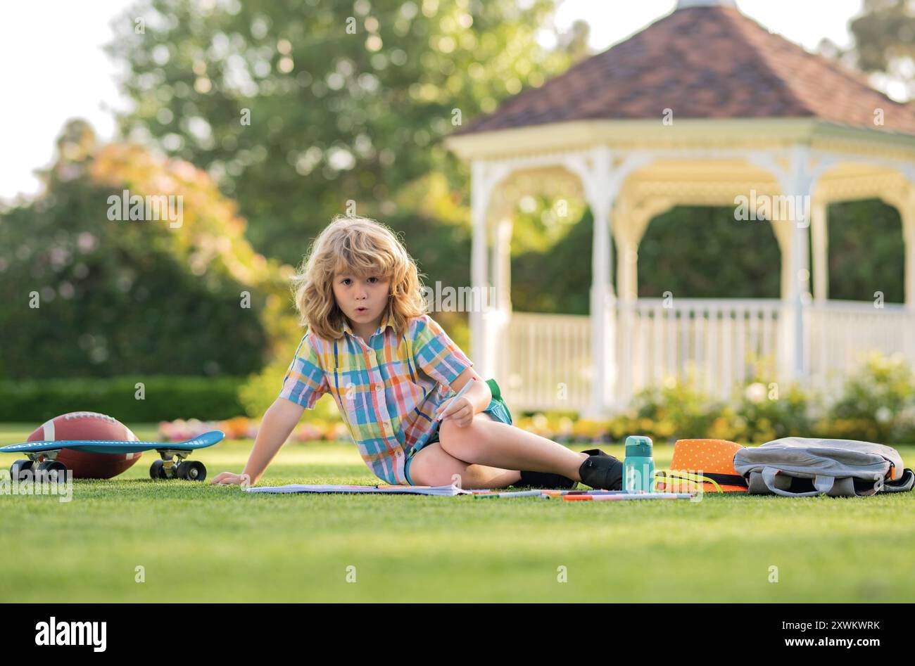 Summer leisure with children. School kid drawing in summer park ...