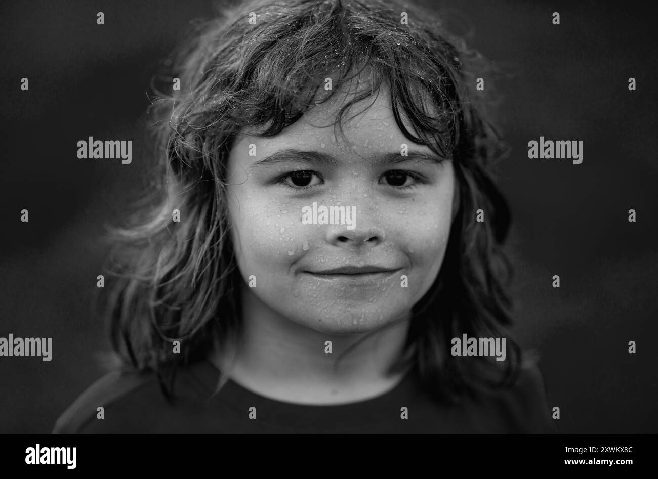 Close up wet child face. Child playing at summer backyard. Water fun in ...