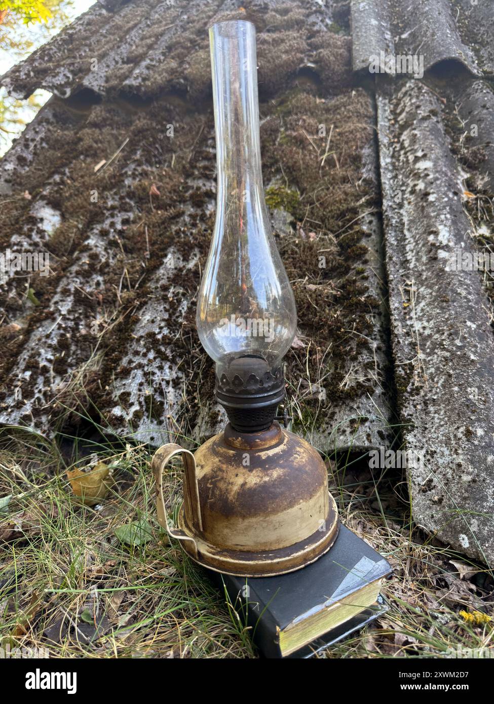 An old kerosene lamp is placed on a worn Bible. In the background ...