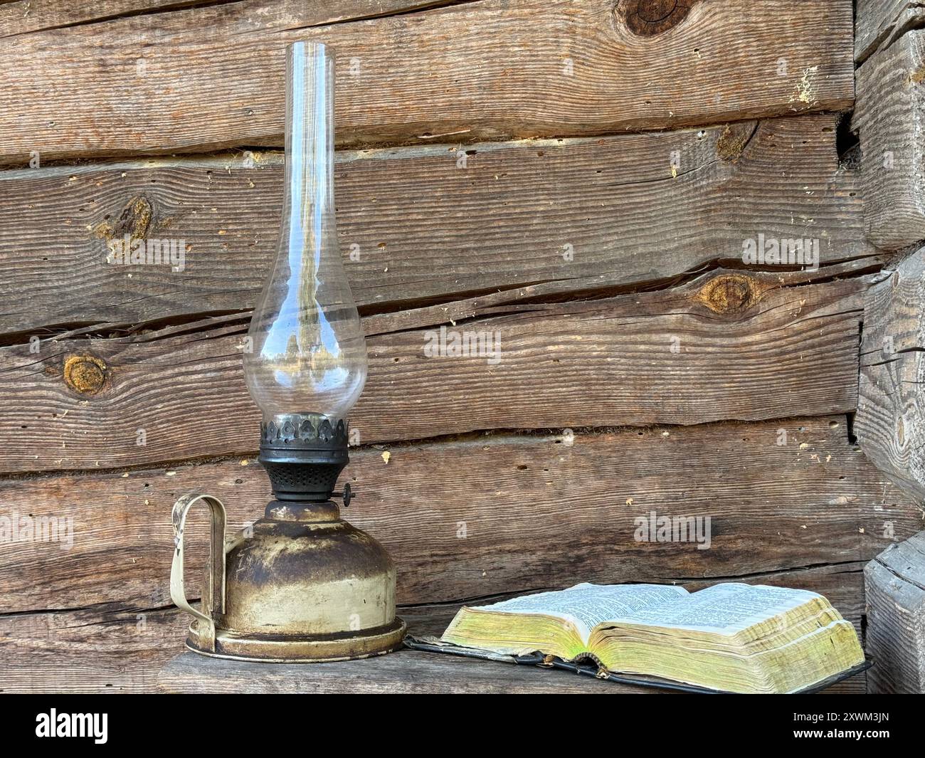 A vintage kerosene lamp against the backdrop of an old log shed. Next ...