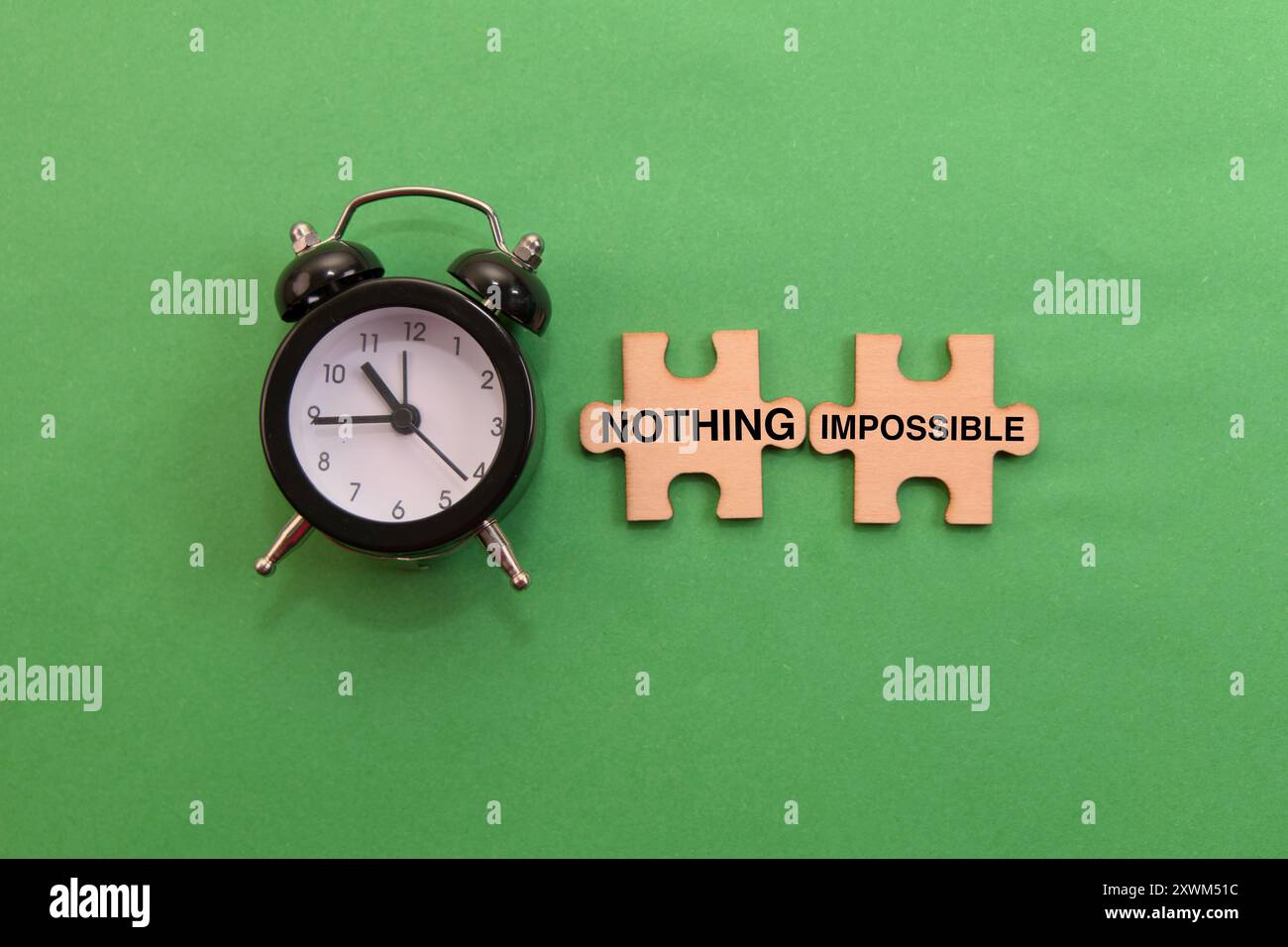 Puzzle pieces join to say "nothing impossible" with alarm clock ...