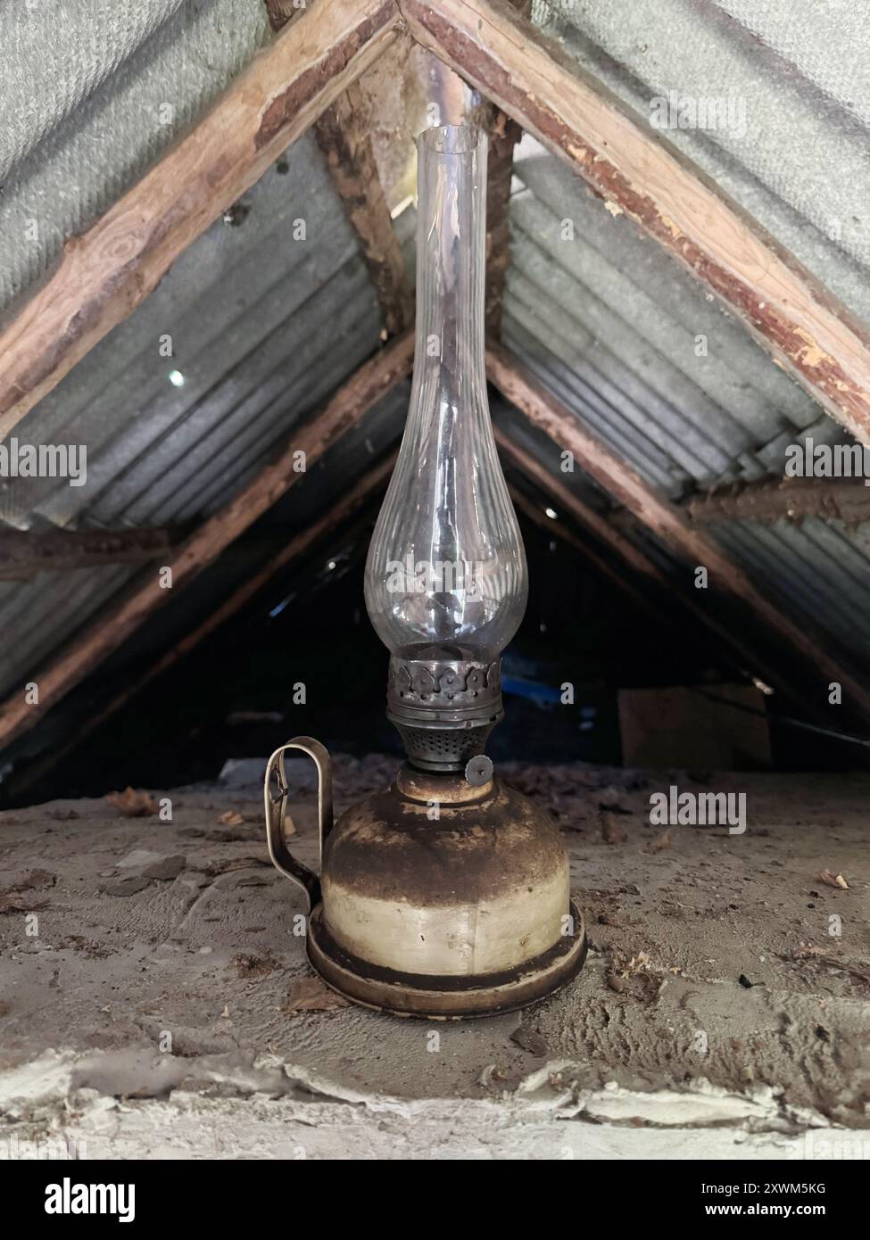 An old kerosene lamp with a glass shade. Inside a room covered with ...