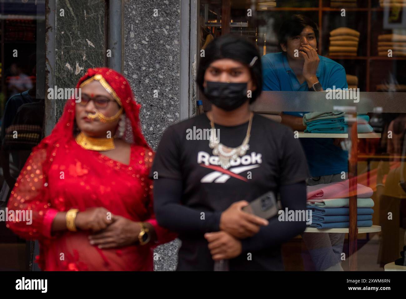 A shopkeeper watches LGBTQ+ people and their supporters rally during the annual pride parade, in ...