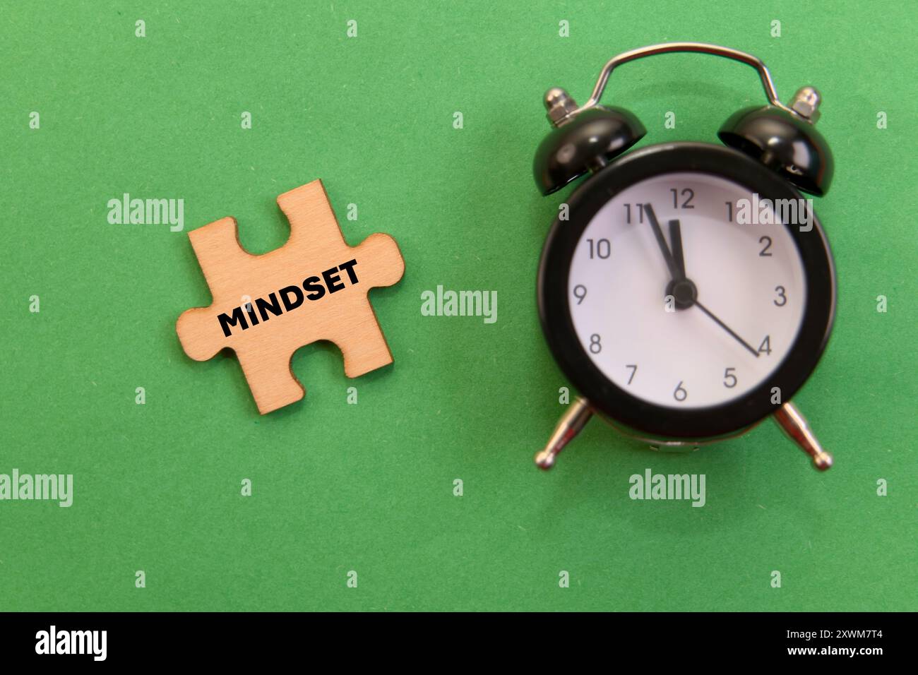 Time to change your mindset. Puzzle piece and alarm clock on green ...
