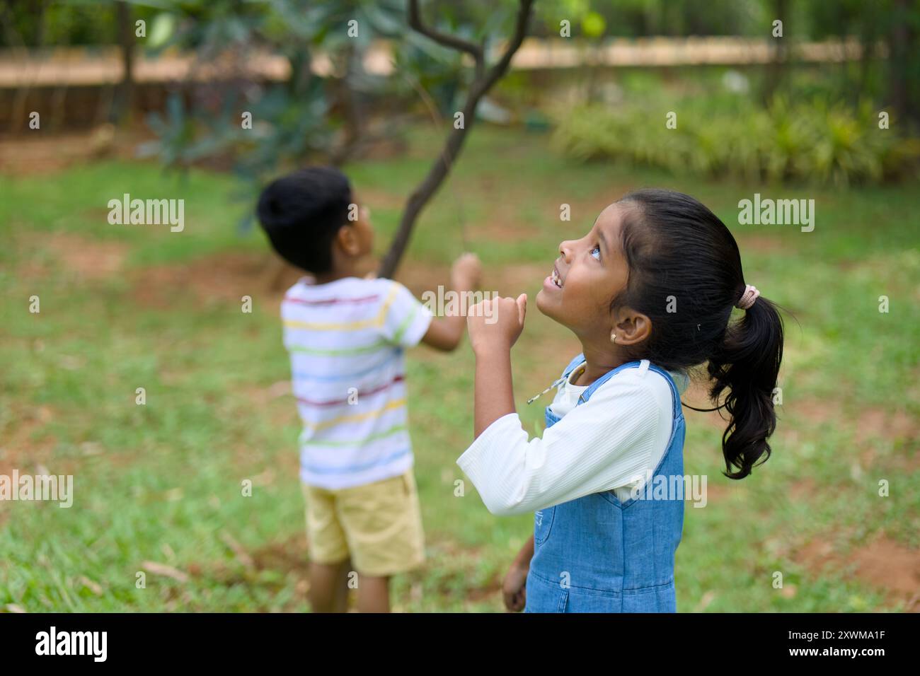 Two young children gaze upwards in awe and excitement, exploring the ...
