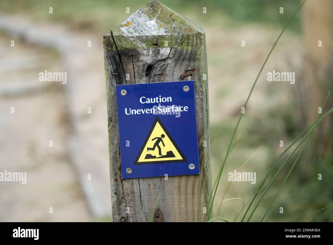caution uneven surfaces warning sign england uk Stock Photo - Alamy