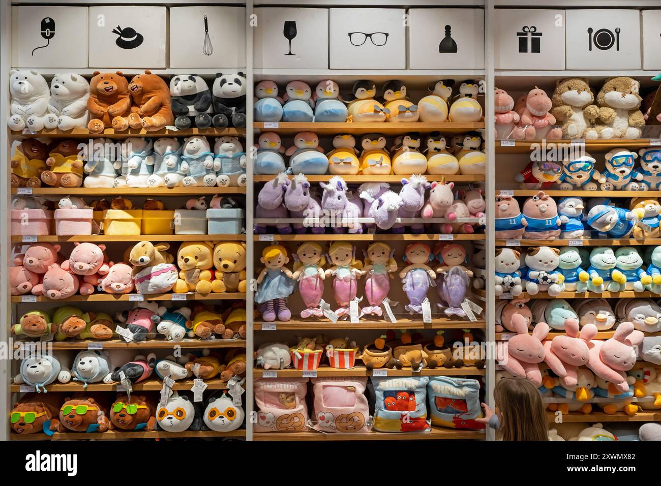 Plush soft toys of different colors on the shelves in Miniso Brand ...
