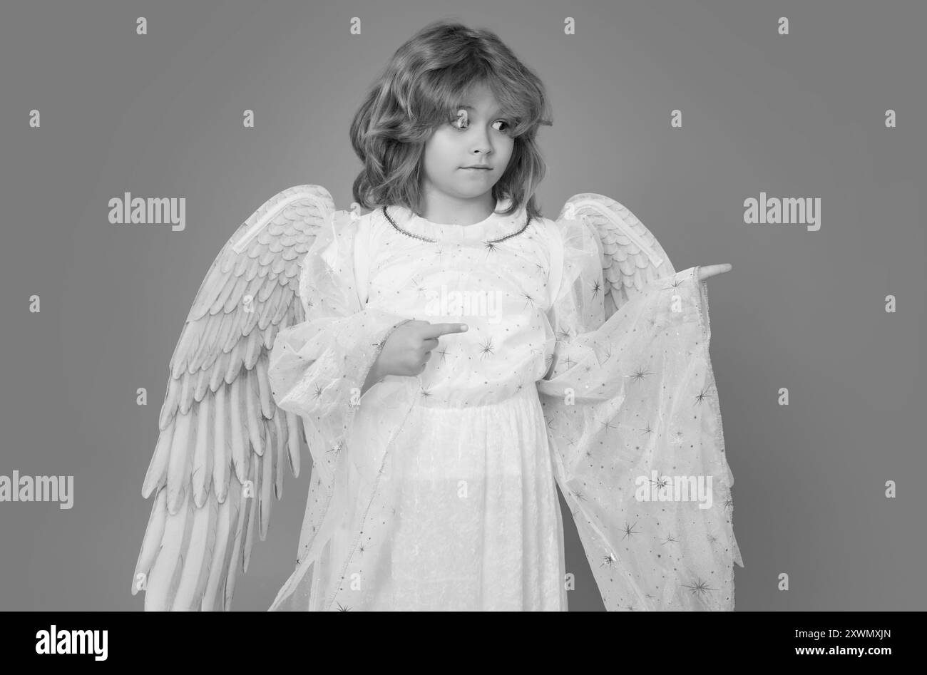 Child angel pointing finger, point gesture. Cute angel child, studio ...