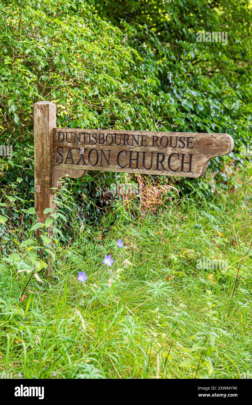 The wooden sign pointing to the Saxon church in the Cotswold village of ...