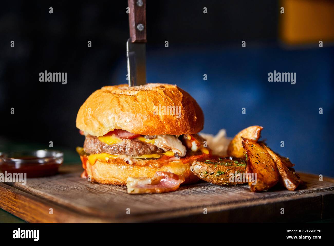 Burger with two beef patties, a wheat bun and cheese, with a knife ...