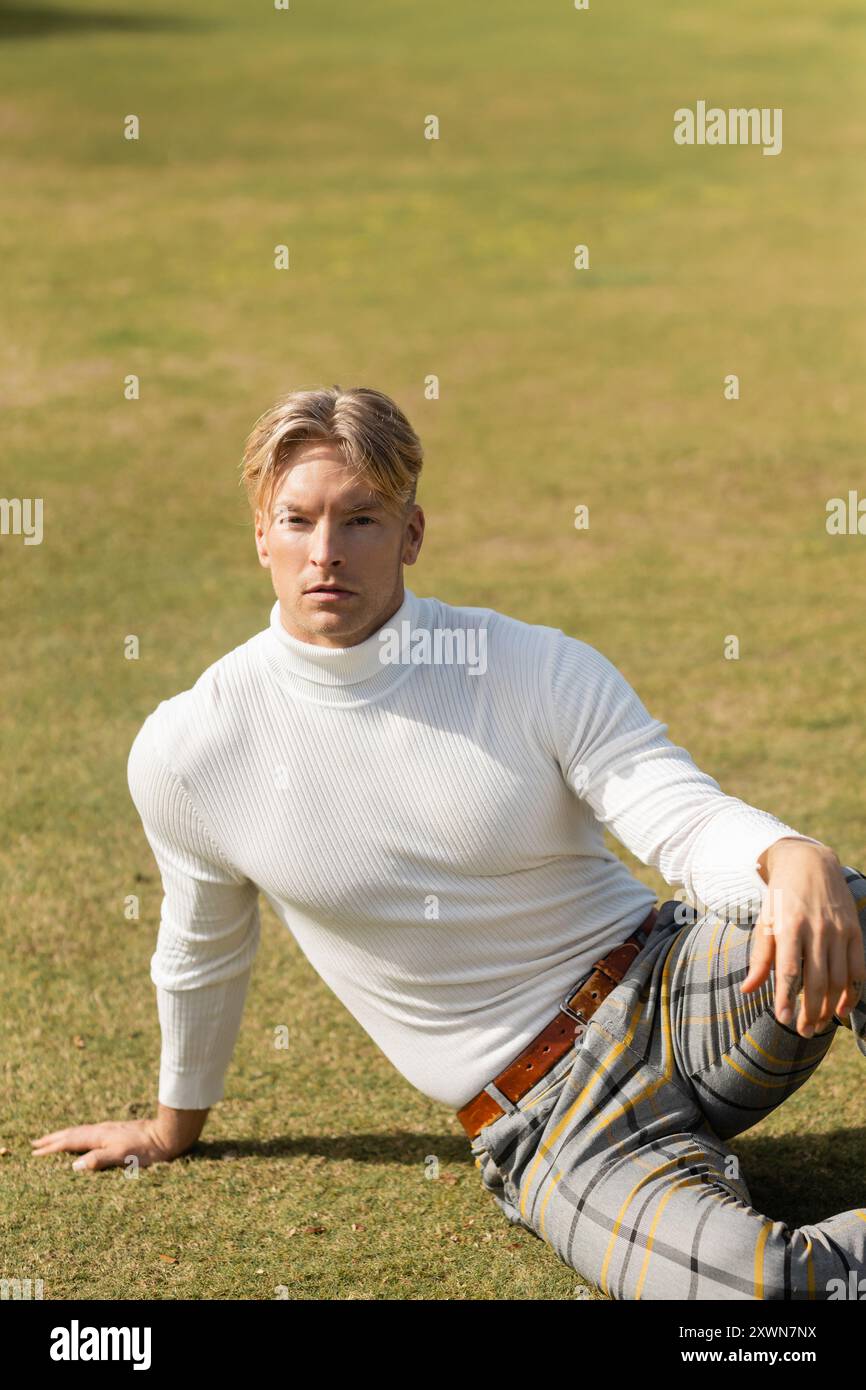 A blonde man in stylish attire sits a park in Miami, Florida Stock ...
