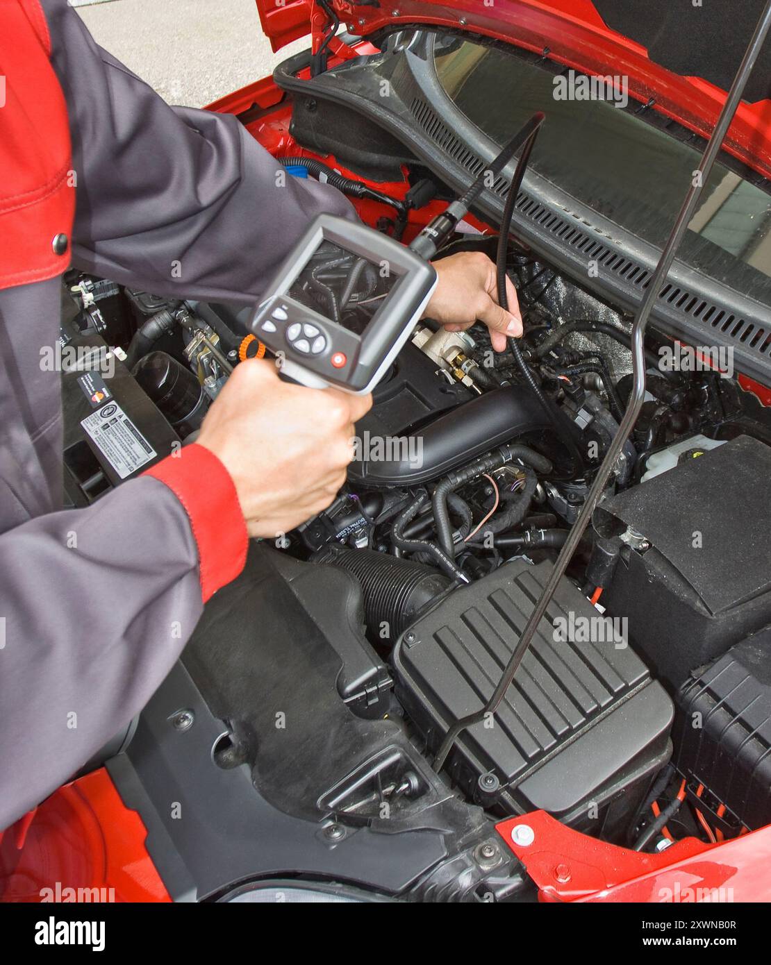 mecanic using a digital endoscope to check a car engine Stock Photo - Alamy