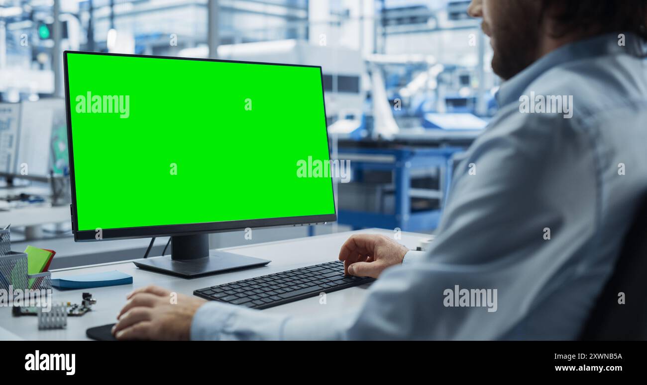 Young Industrial Software Engineer Working on a Desktop Computer with ...