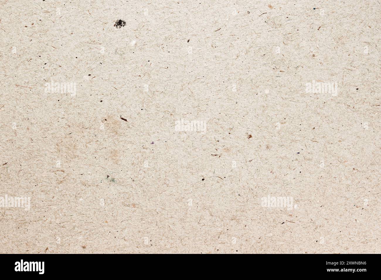 Light brown textured paper surface with small flecks and fibers ...