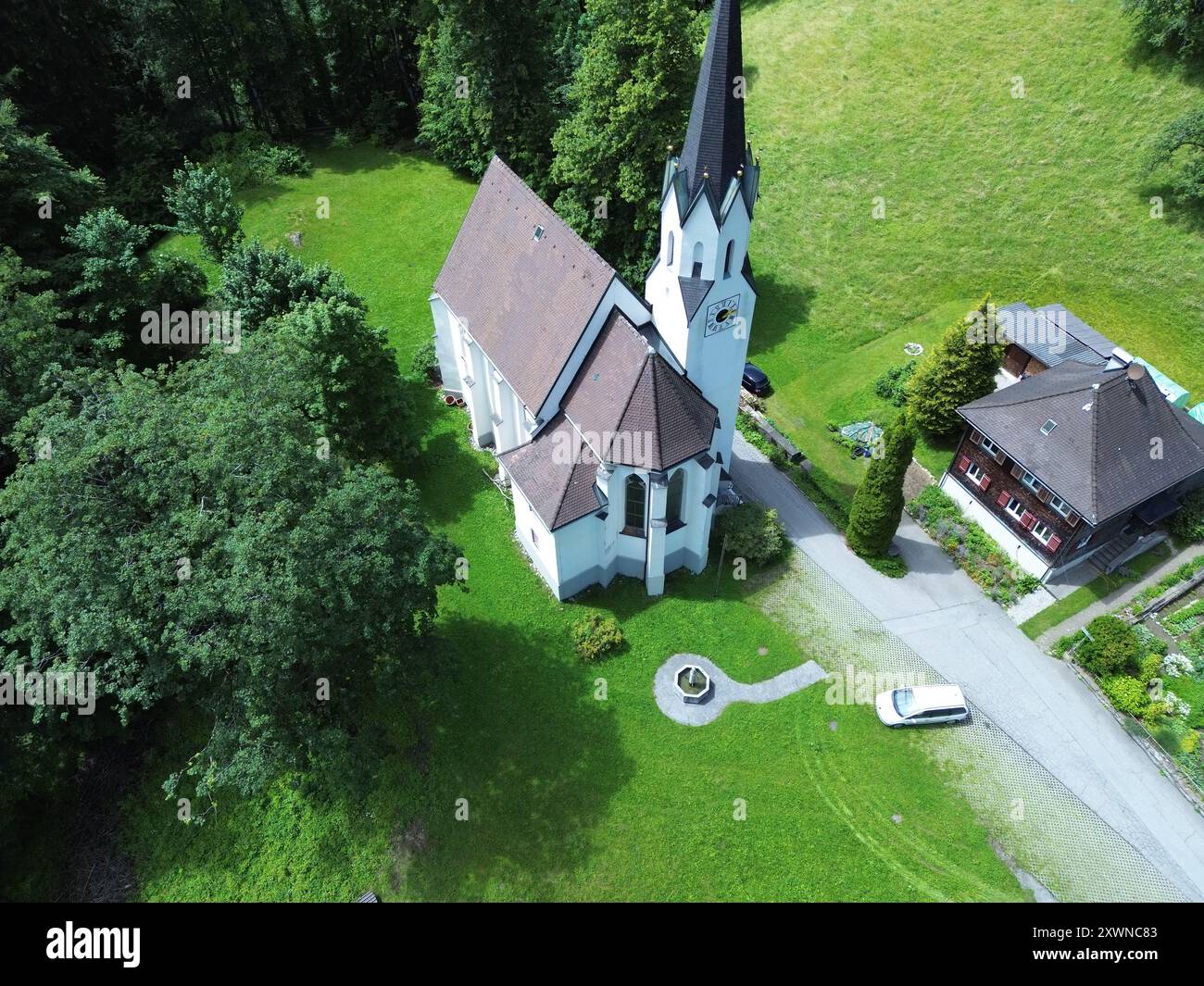 An aerial view of Kuratienkirche Meschach surrounded by lush greenery ...