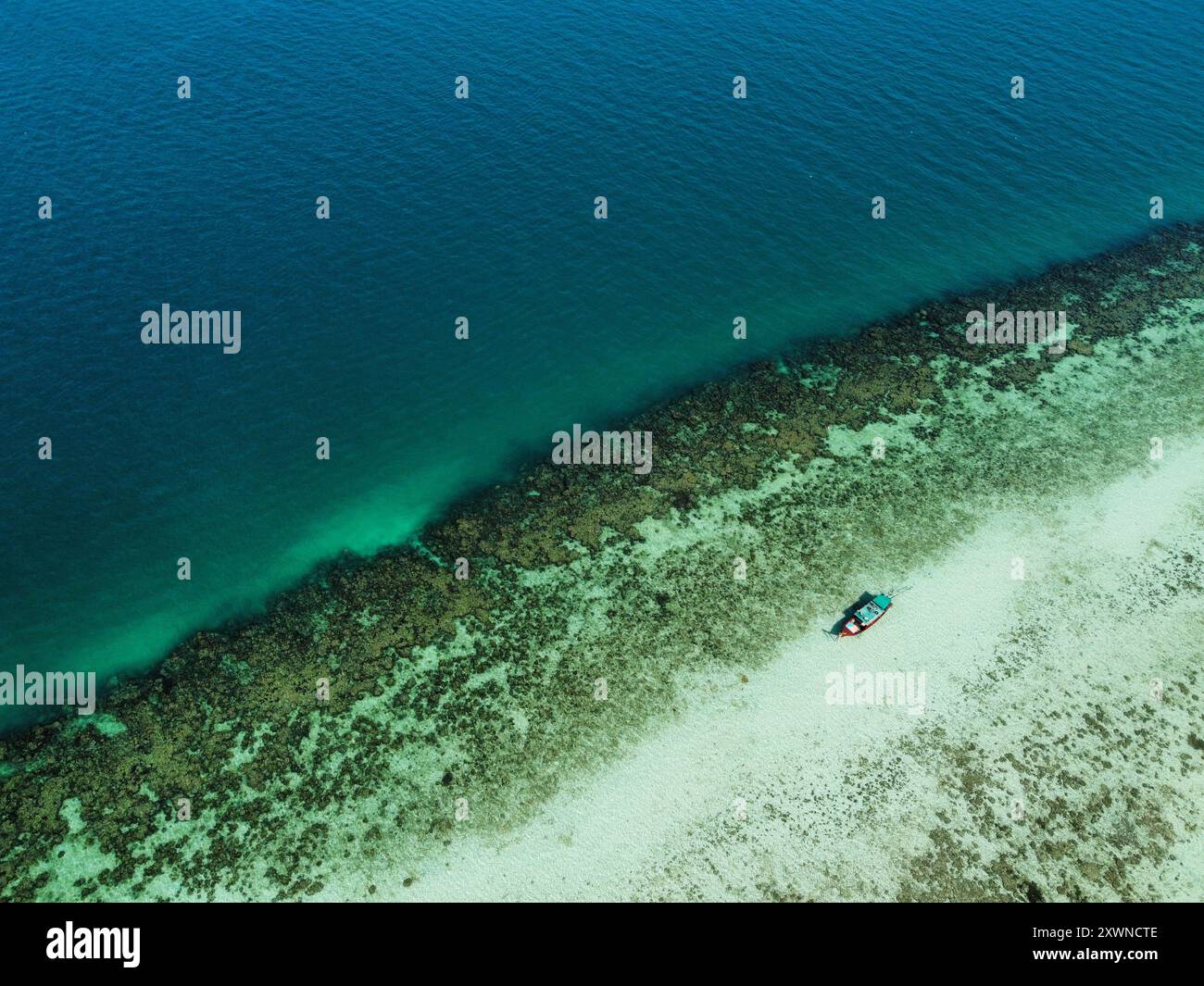 Aerial view of a long tail boat sailing over an underwater cliff on Koh ...