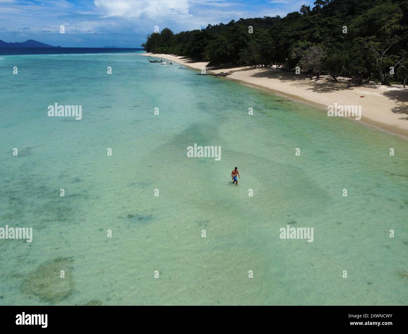 Aerial view of the Koh Kradan beach with a traveler exploring the coral ...