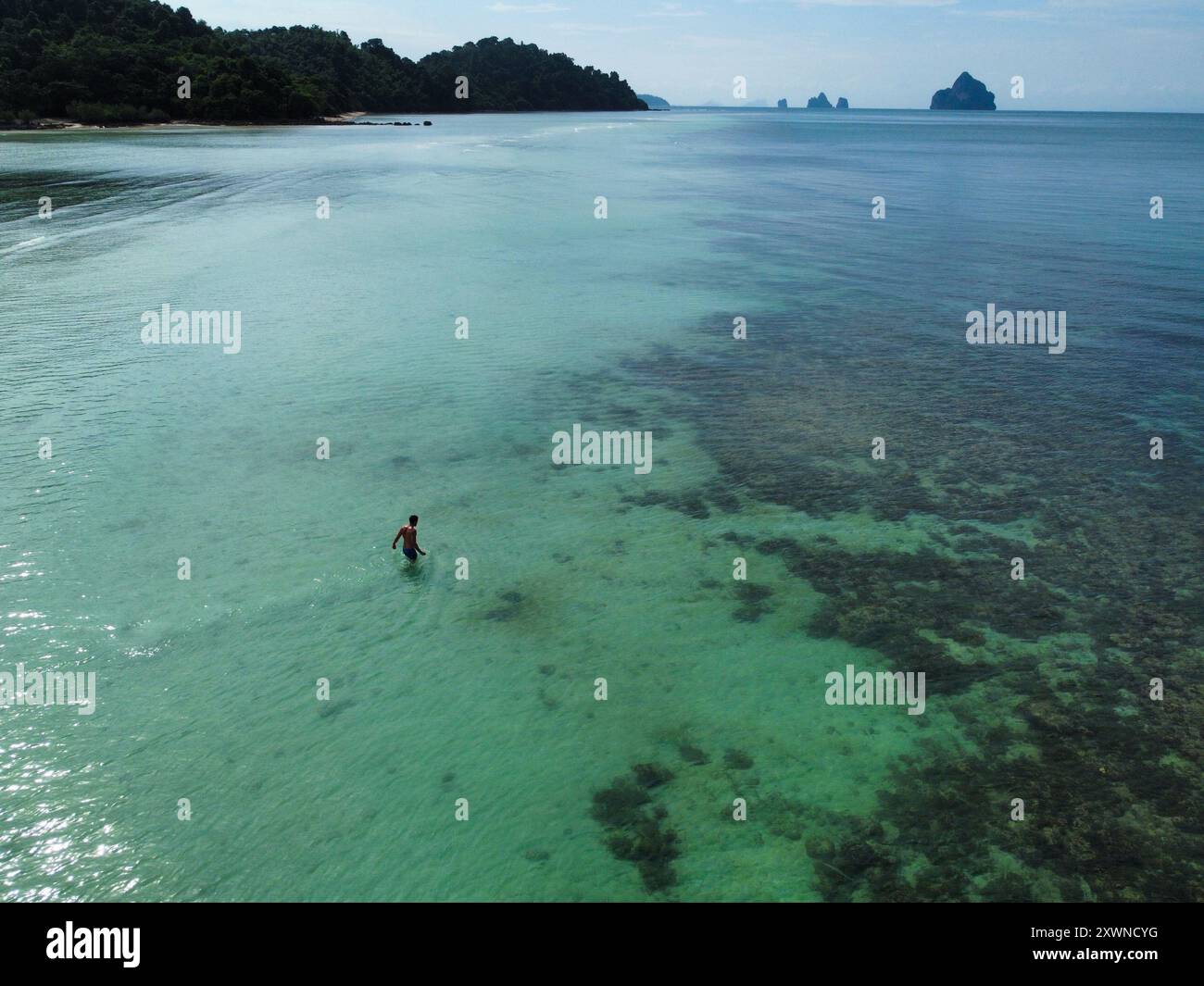 Aerial view of the Koh Kradan beach with a traveler exploring the coral ...