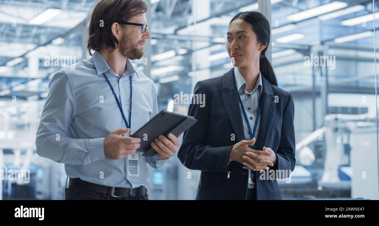 Two Diverse Engineers Walking in Office, Using Tablet Computer at a ...