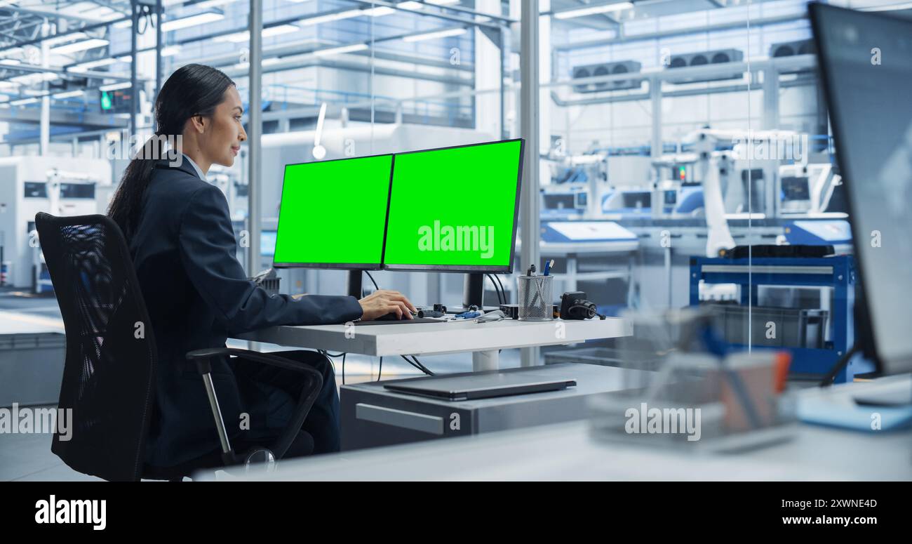 Female Robotics Technician Working on Desktop Computer with Green Screen Chromakey Mock Up ...