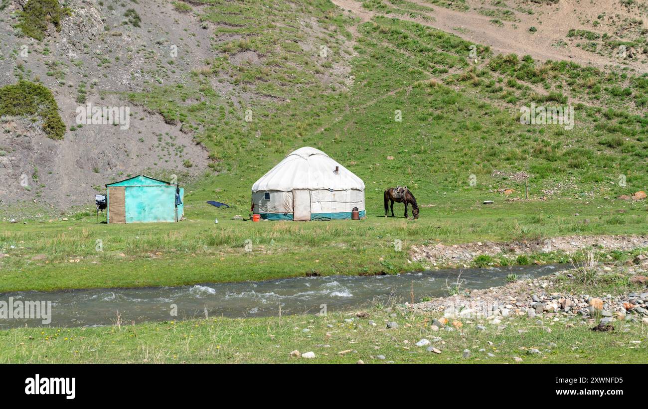 A traditional yurt tent set in the Kyrgyzstan countryside, reflecting ...