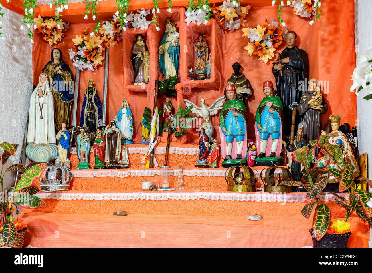 Colorful altar with several Catholic saints decorated with plants and ...
