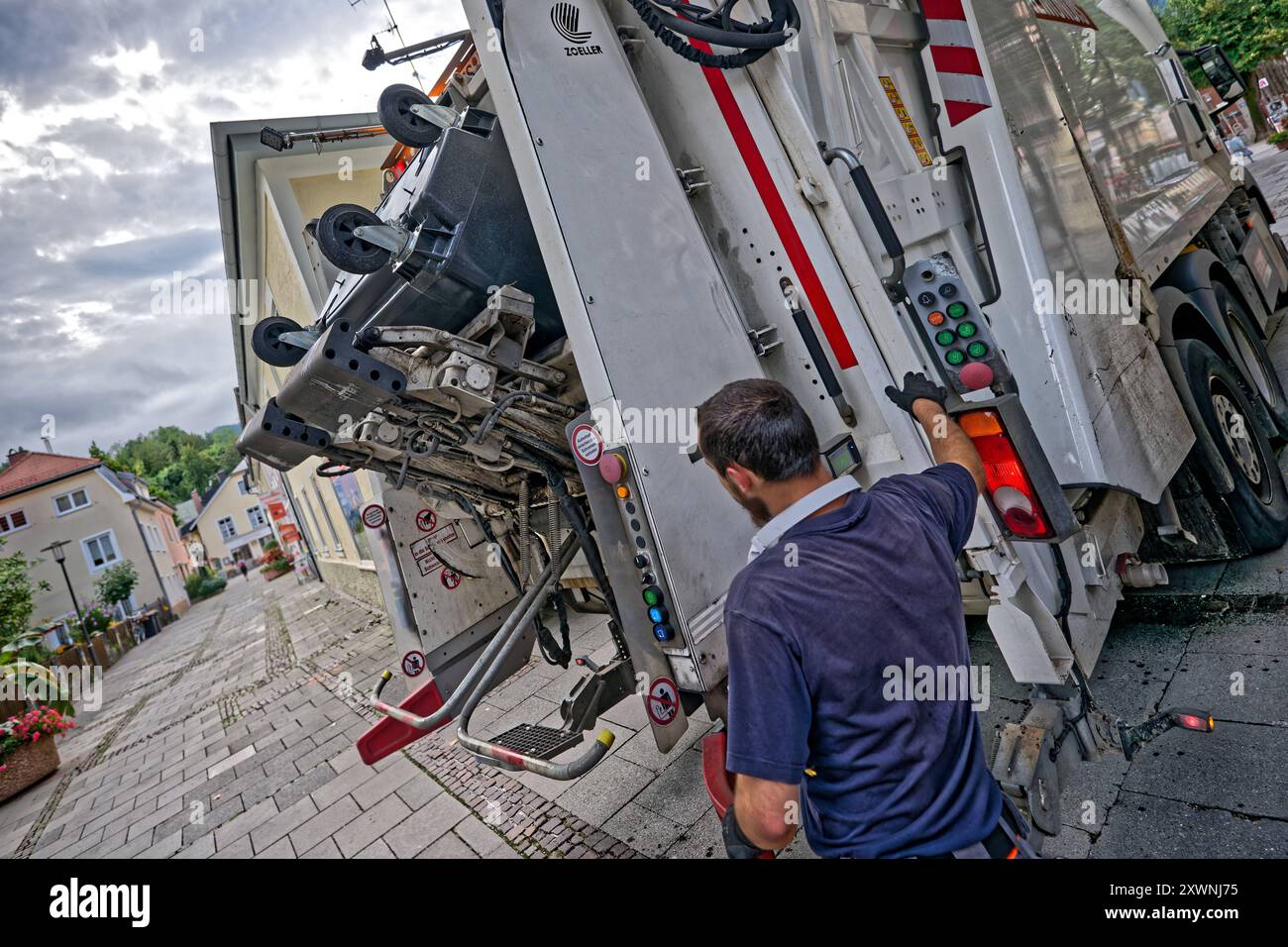 Übervoll. Abfallentsorgung dürch den Müllmann mit dem Müllwagen. Der ...