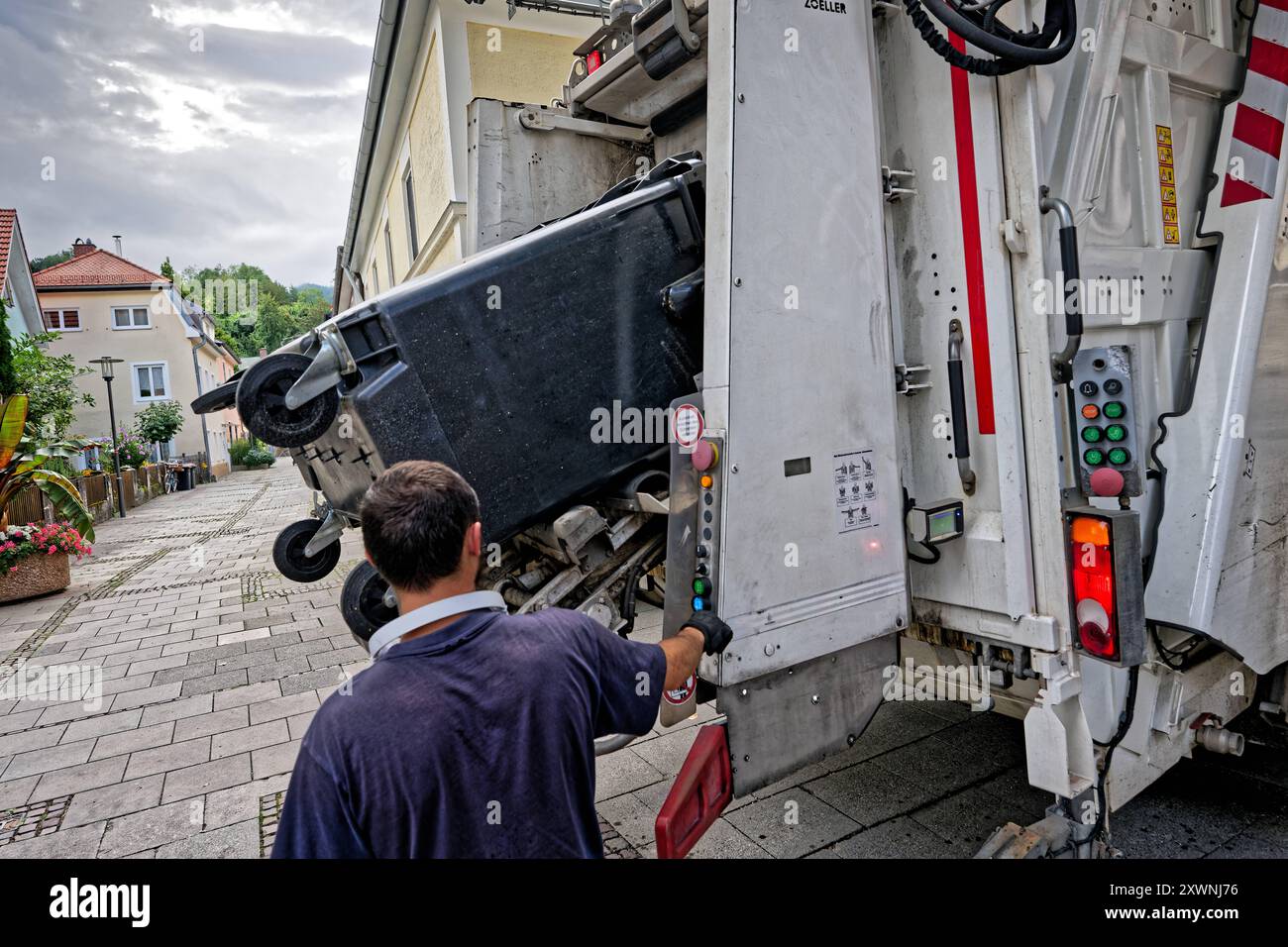 Übervoll. Abfallentsorgung dürch den Müllmann mit dem Müllwagen. Der ...