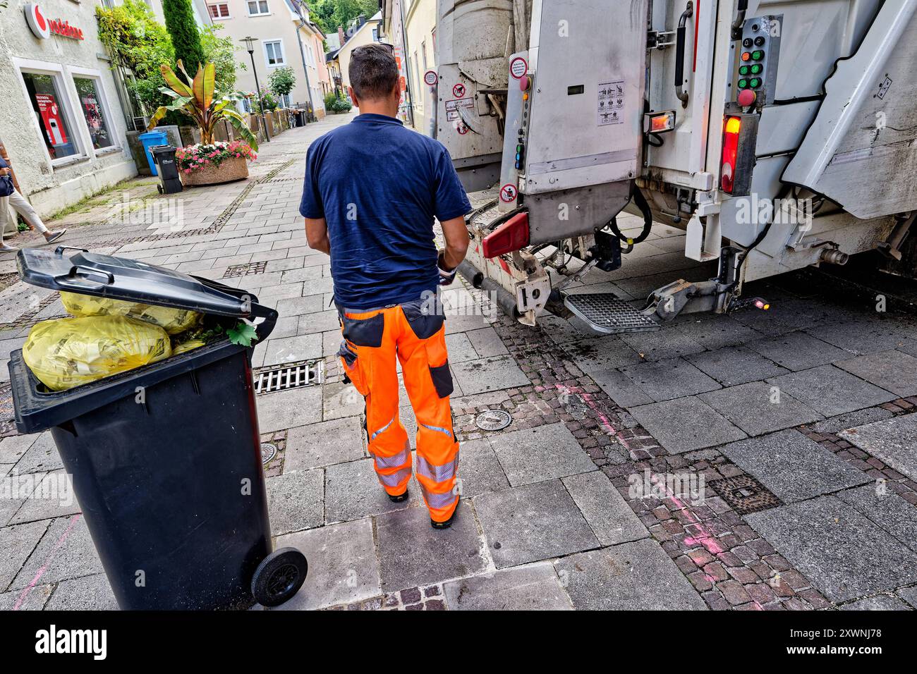 Übervoll. Abfallentsorgung dürch den Müllmann mit dem Müllwagen. Der ...