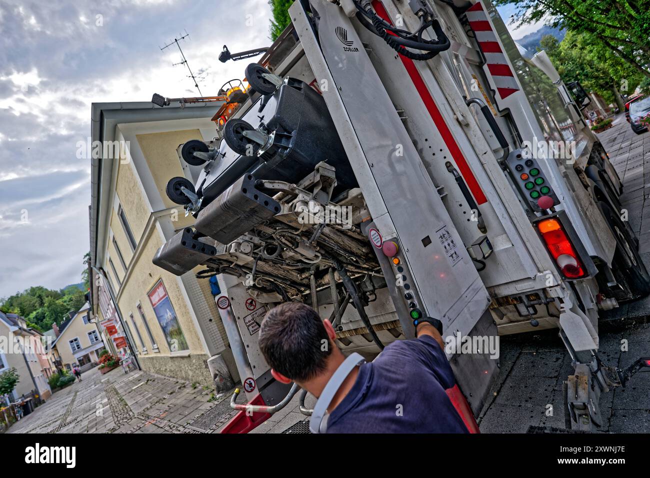 Übervoll. Abfallentsorgung dürch den Müllmann mit dem Müllwagen. Der ...