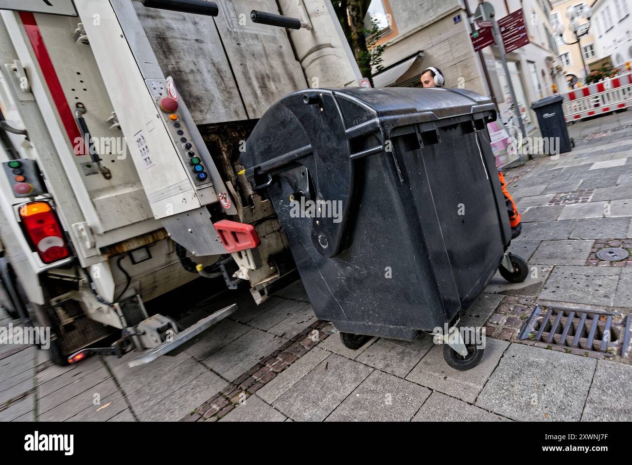 Übervoll. Abfallentsorgung dürch den Müllmann mit dem Müllwagen. Der ...