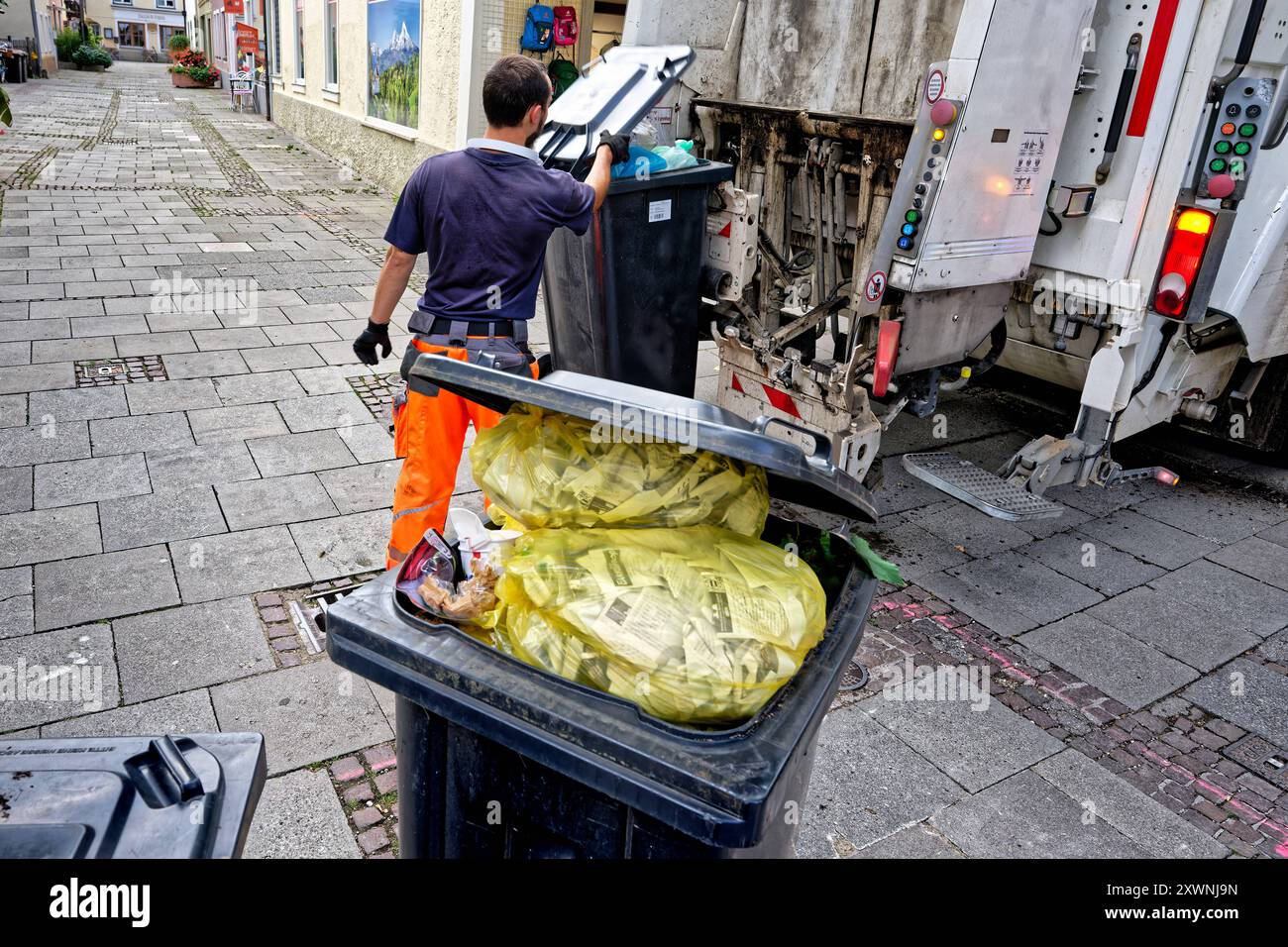 Übervoll. Abfallentsorgung dürch den Müllmann mit dem Müllwagen. Der ...