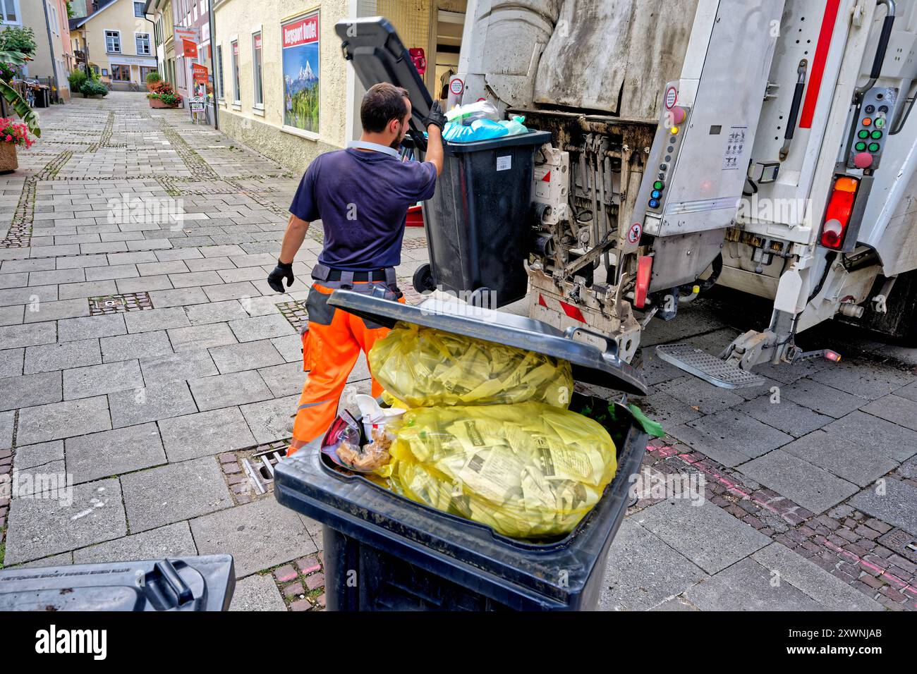 Übervoll. Abfallentsorgung dürch den Müllmann mit dem Müllwagen. Der ...