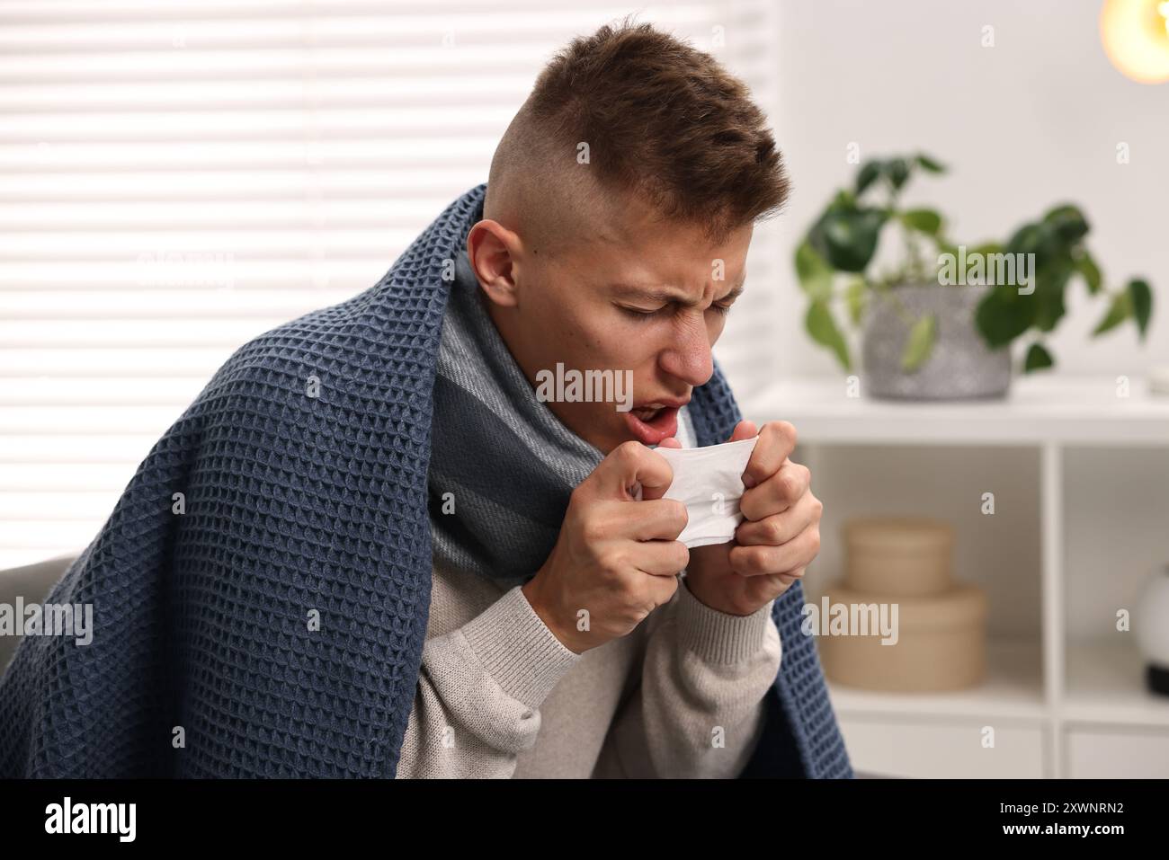 Cold symptom. Young man coughing at home Stock Photo - Alamy
