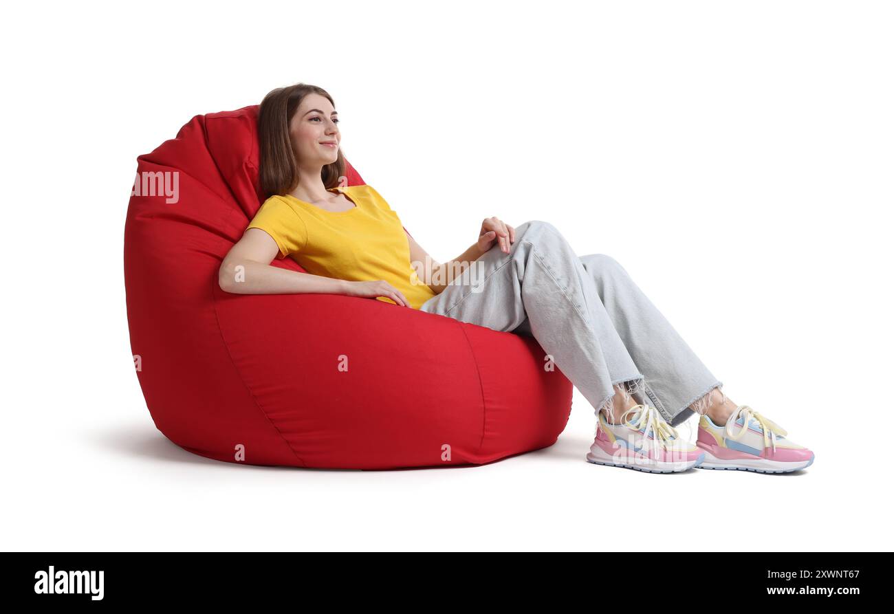 Beautiful young woman sitting on red bean bag chair against white ...