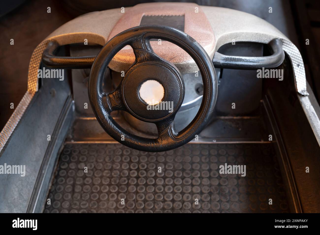 View inside an empty bumper car with steering wheel and handles to hold ...