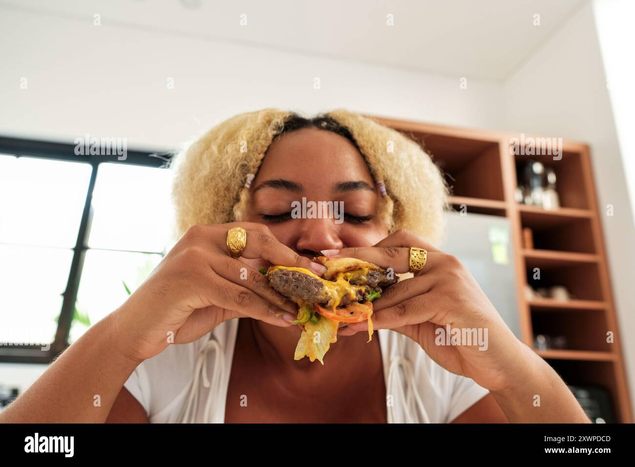African american woman eating cheeseburger hi-res stock photography and ...