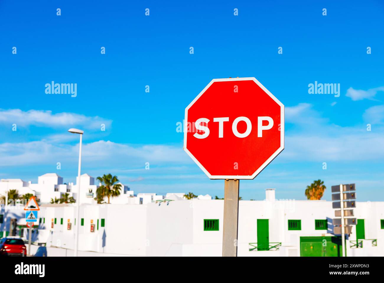 Stop sign is standing in front of a buildings. Red stop sign stands ...