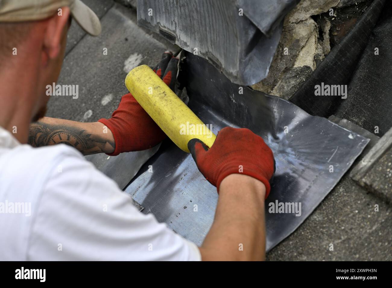 Roofing work, man on roof installing lead flashing around chimney ...