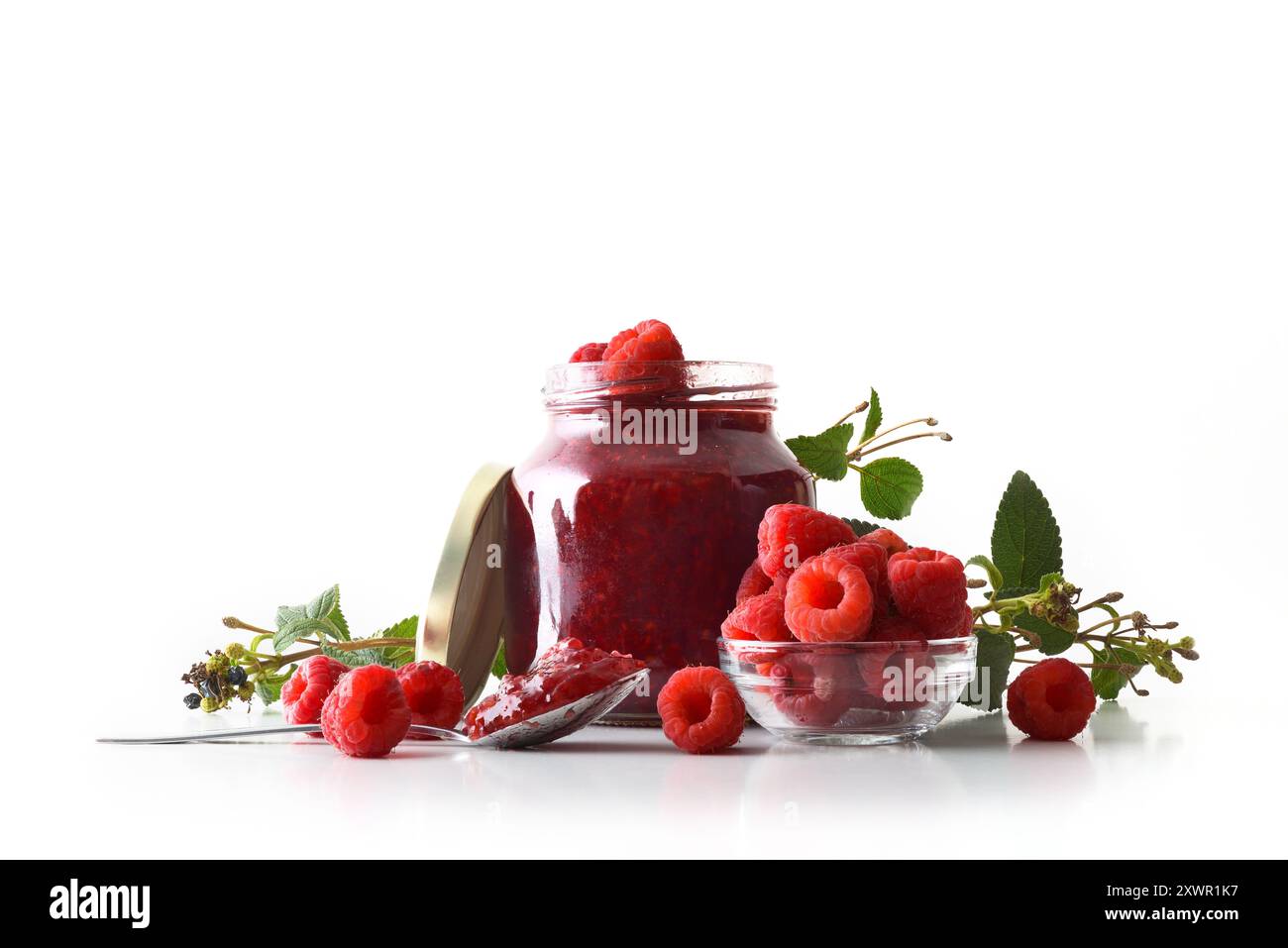 Jar of raspberry jam isolated on white background with fruit around it ...